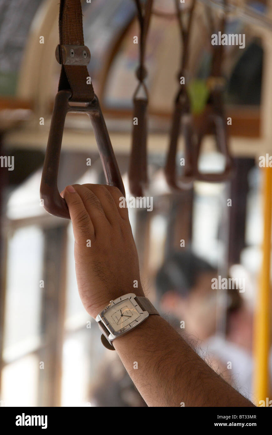 Tube commuters time, Passenger using the hand hold leather handle ...