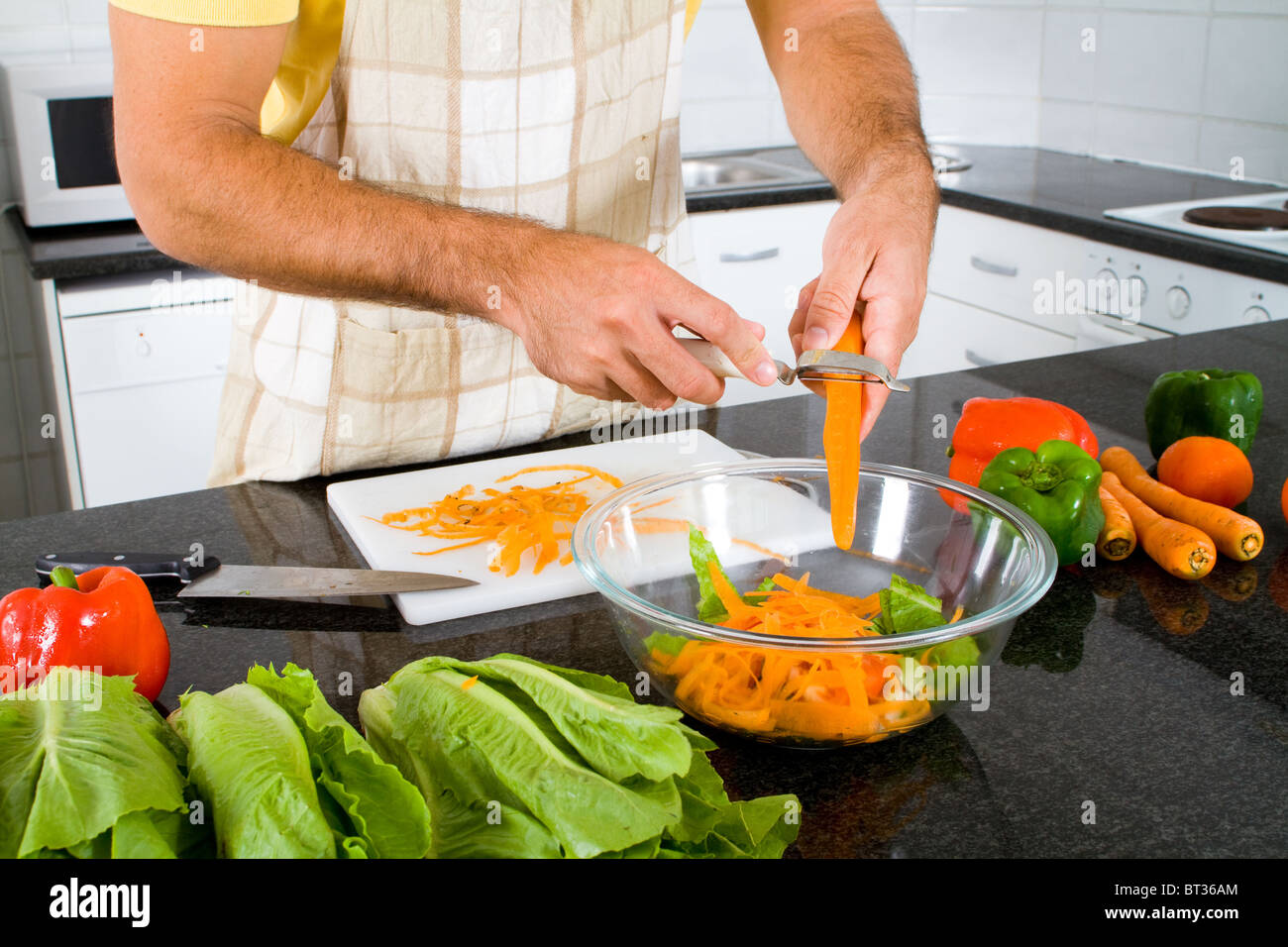 young man cutting vegetables in kitchen Stock Photo - Alamy