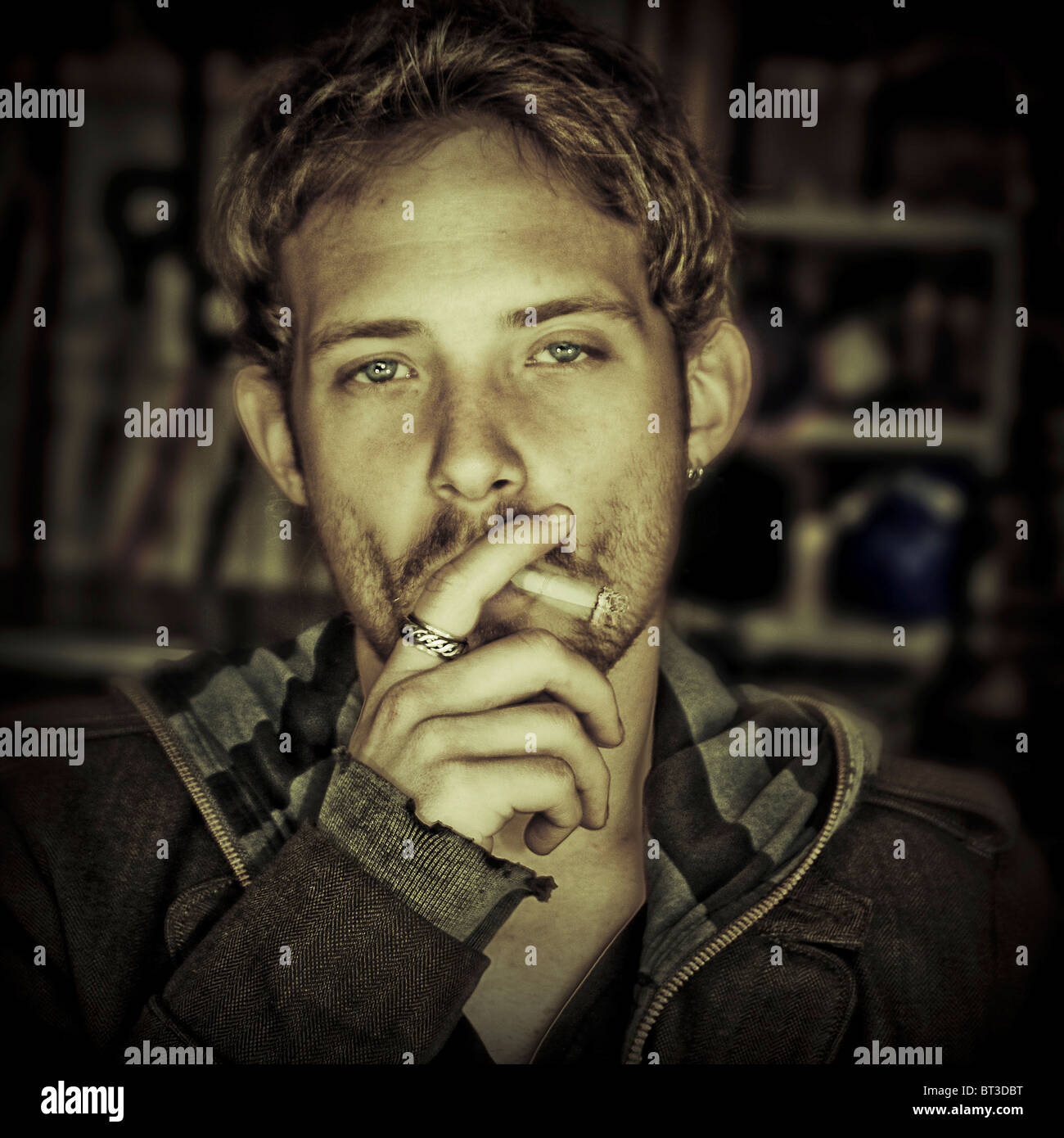 Young male smoking a cigarette looking at camera Stock Photo - Alamy