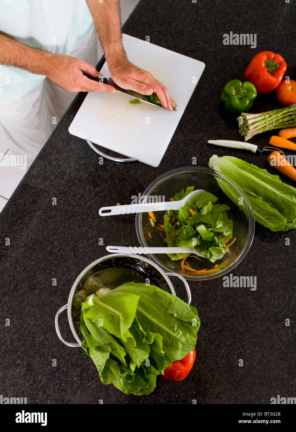 young man cutting vegetables in kitchen Stock Photo - Alamy