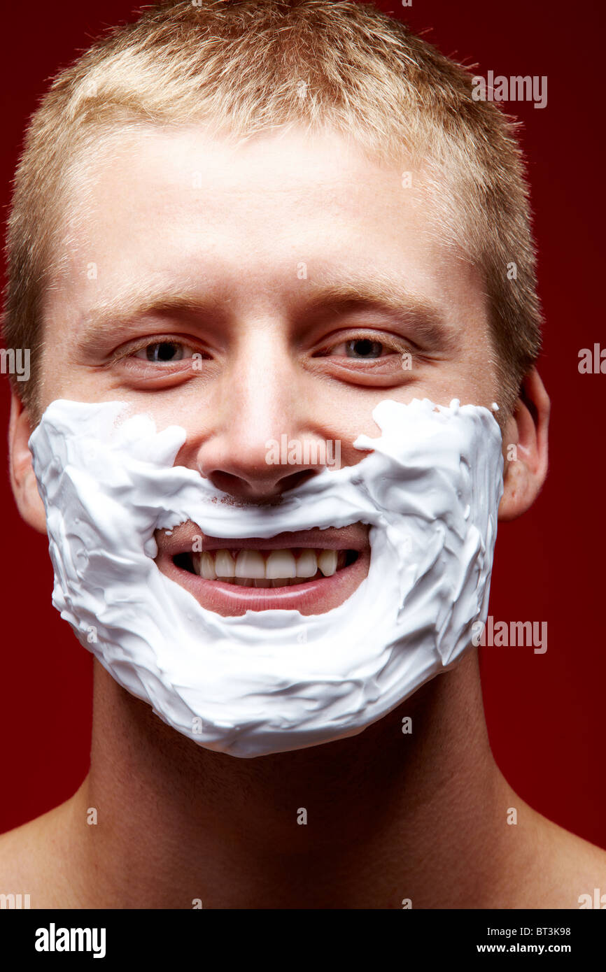 Portrait of handsome man with foam on face on a red background Stock ...
