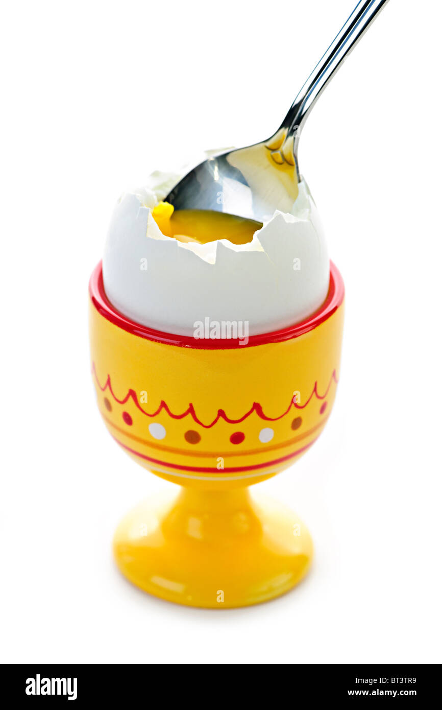 Closeup of soft boiled egg in cup with spoon on white background Stock ...