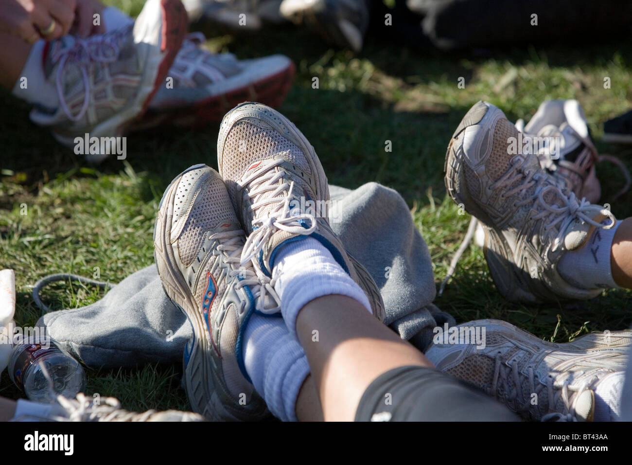 A group of feet in trainers of people sitting on the ground Stock Photo ...