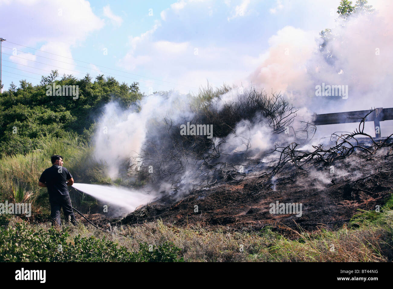Fire fighter fighting the flames of a bush fire Stock Photo - Alamy