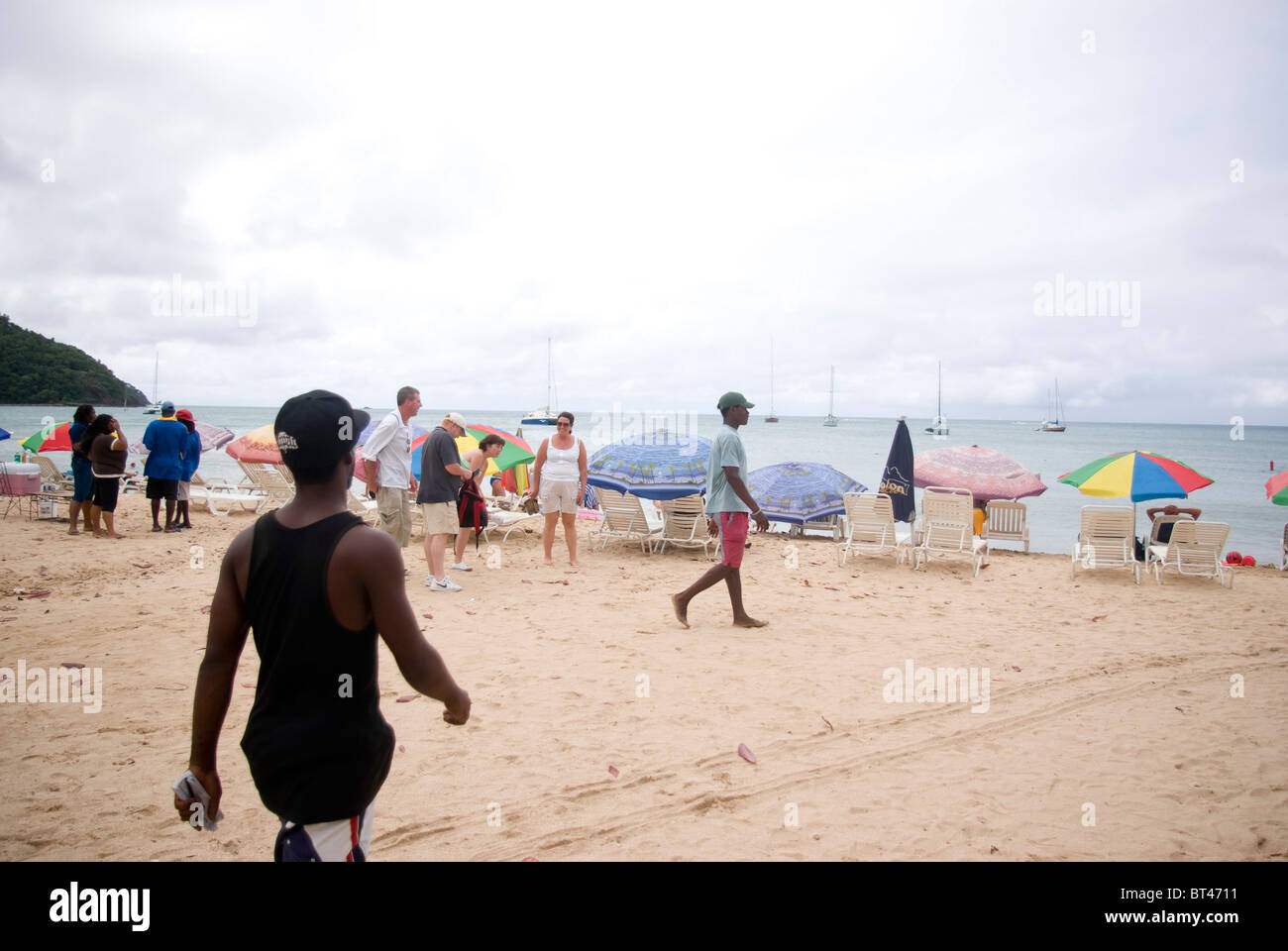 people at the beach having fun along with colorful breach umbrellas at ...