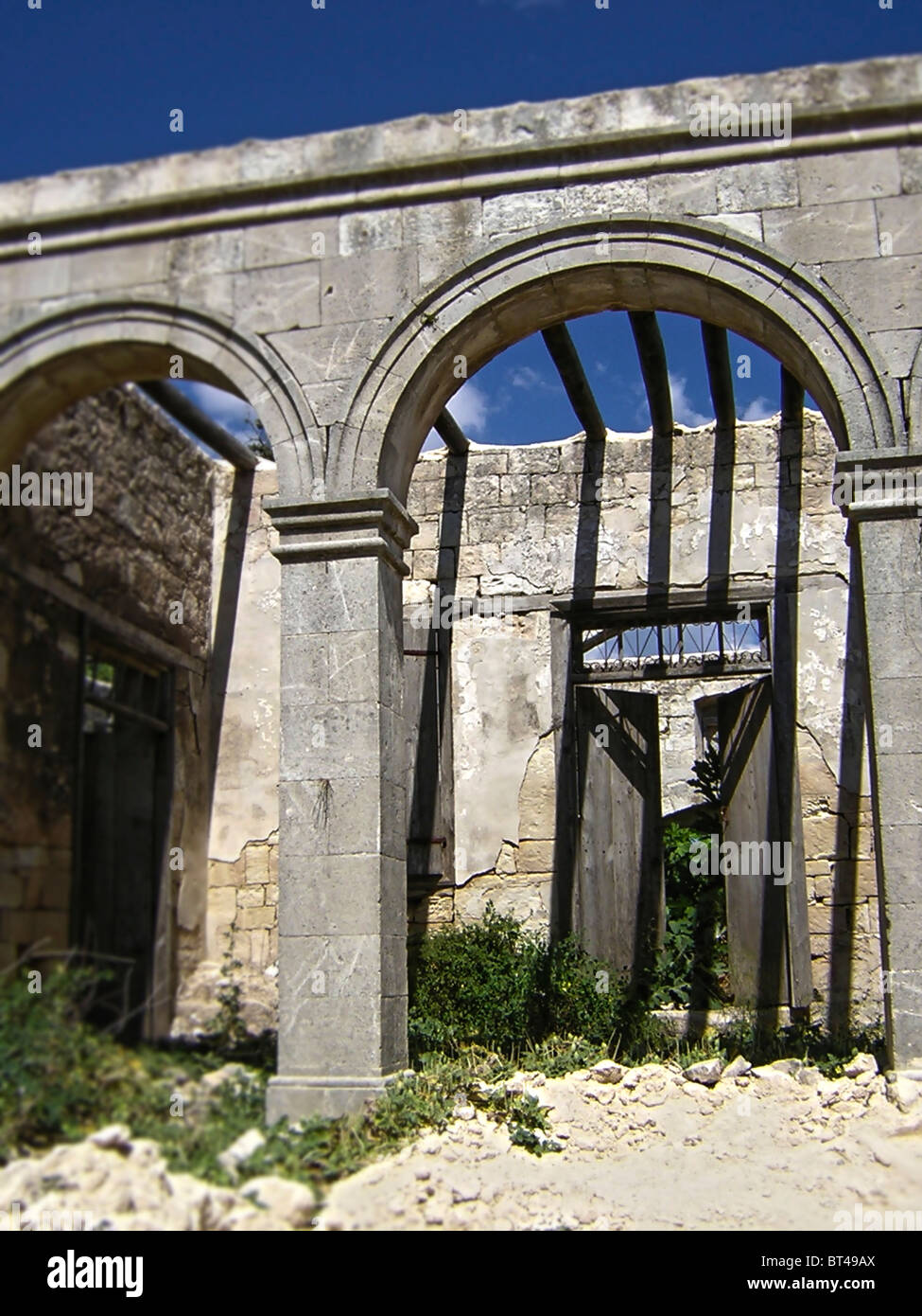 An old stone arch entrance to a derelict building Stock Photo - Alamy