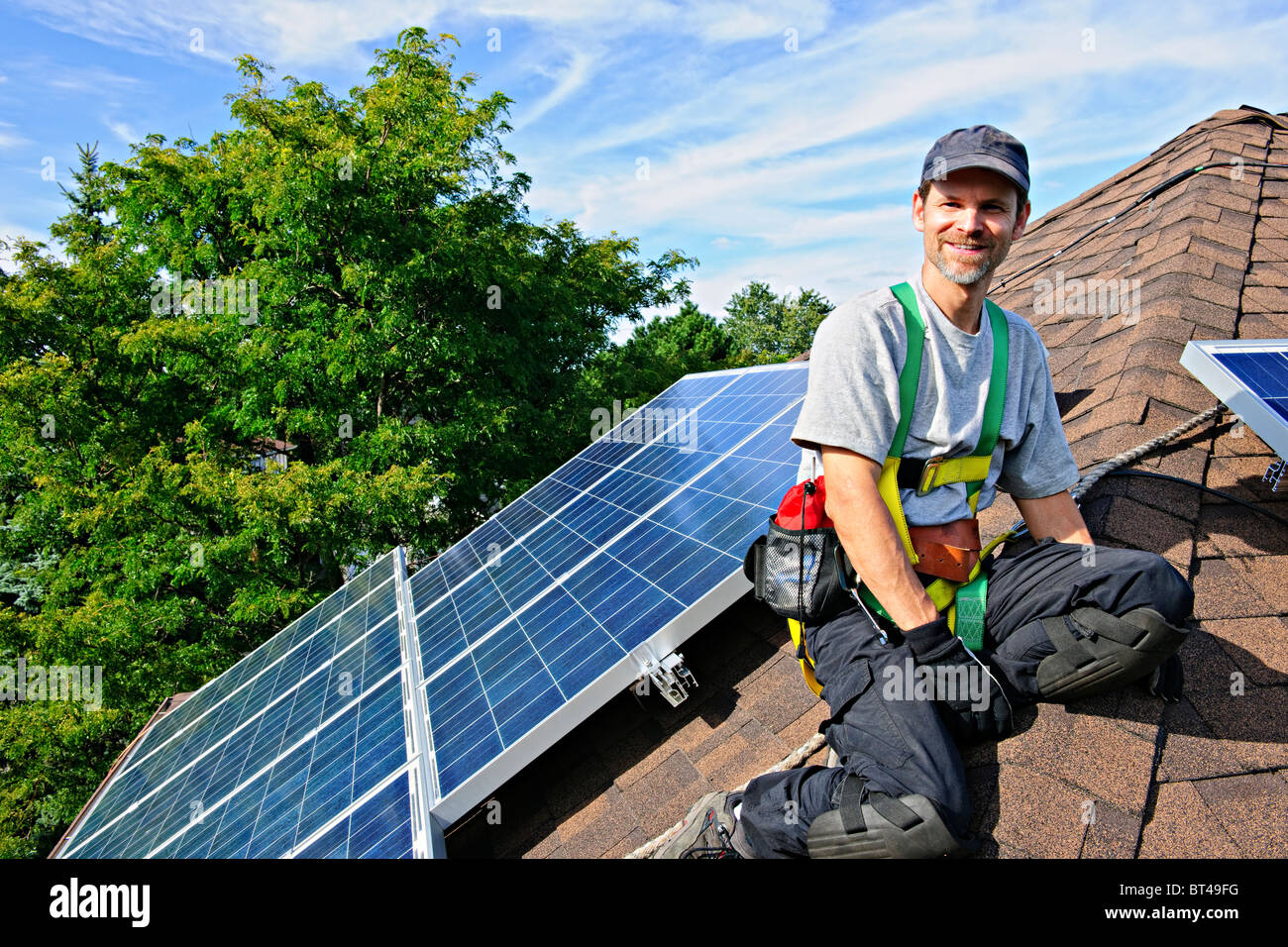 Man installing alternative energy photovoltaic solar panels on roof ...