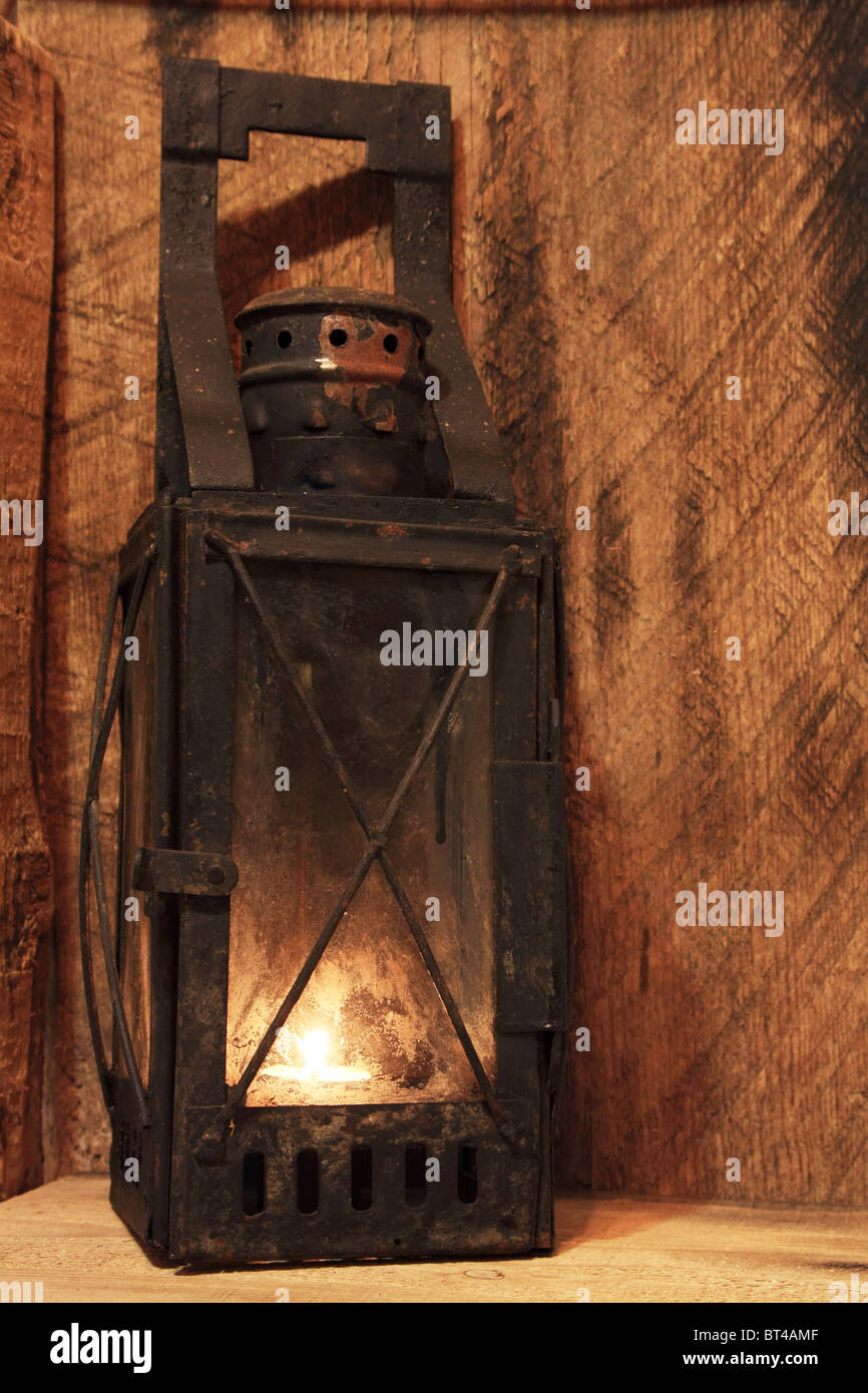 Old lamp with lighted candle on wooden background Stock Photo - Alamy