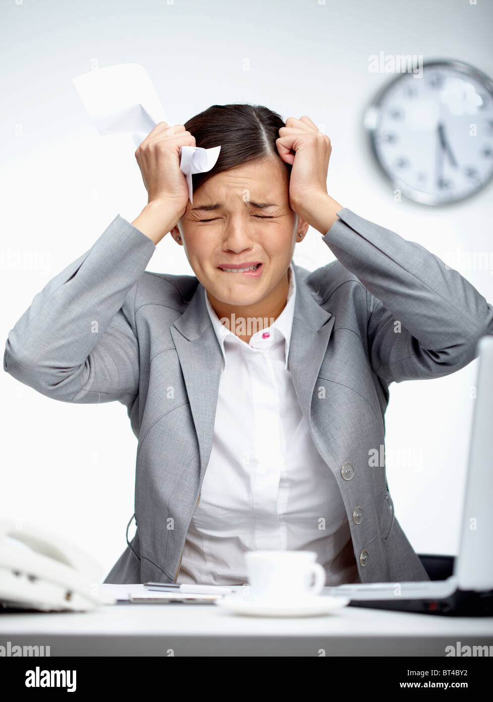 Image of young employer touching her head in frustration at workplace ...
