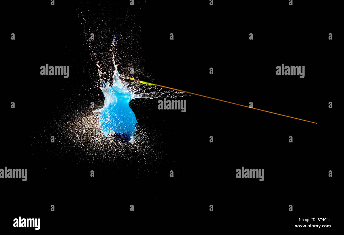 Balloon bursting punctured by arrow.High speed photography. Isolated on ...