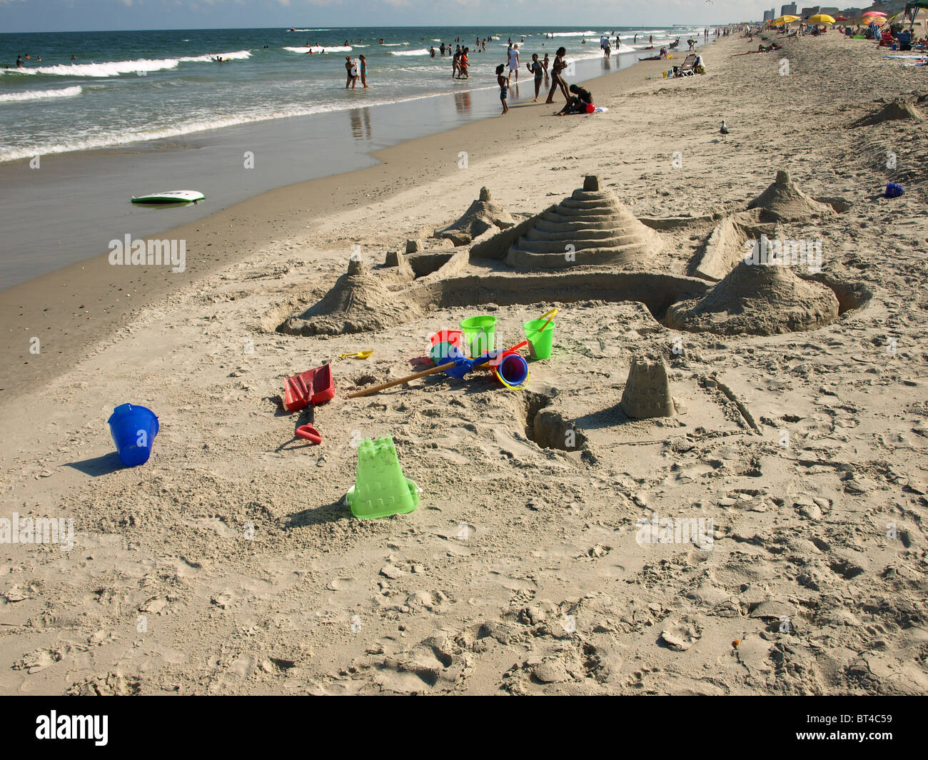 sand castle and toys on beach near ocean waves Stock Photo - Alamy