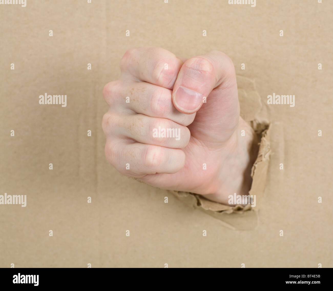 Gesture male hand through from hole in cardboard Stock Photo - Alamy