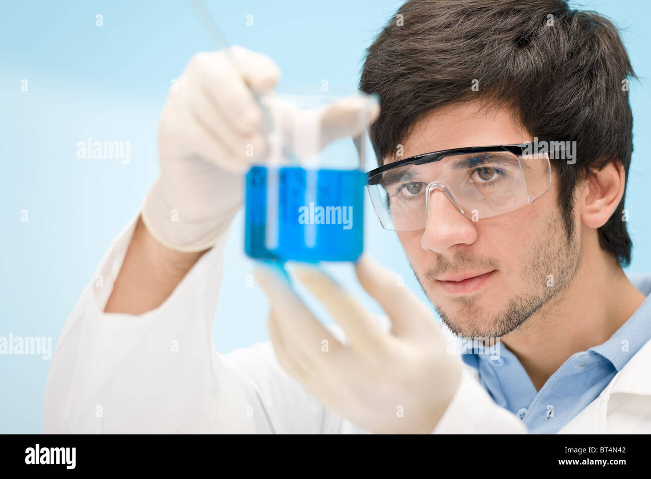 Chemistry experiment - scientist in laboratory, wear protective eyewear ...