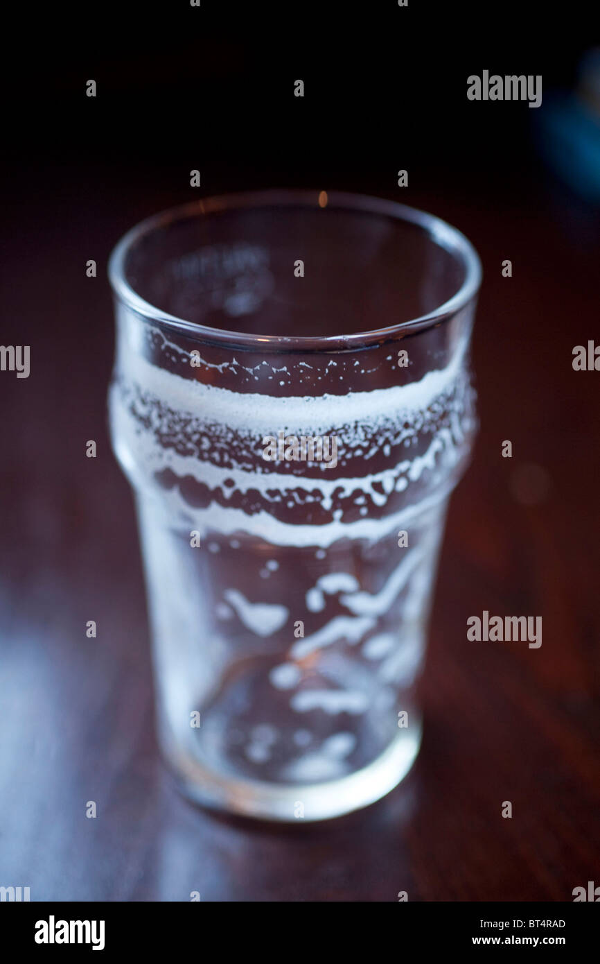 Empty pint glass on a pub table Stock Photo - Alamy