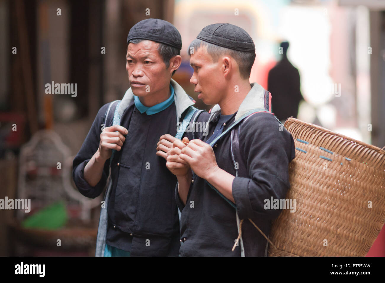 Two Black Hmong men check out goods at the market in Sapa, Vietnam ...