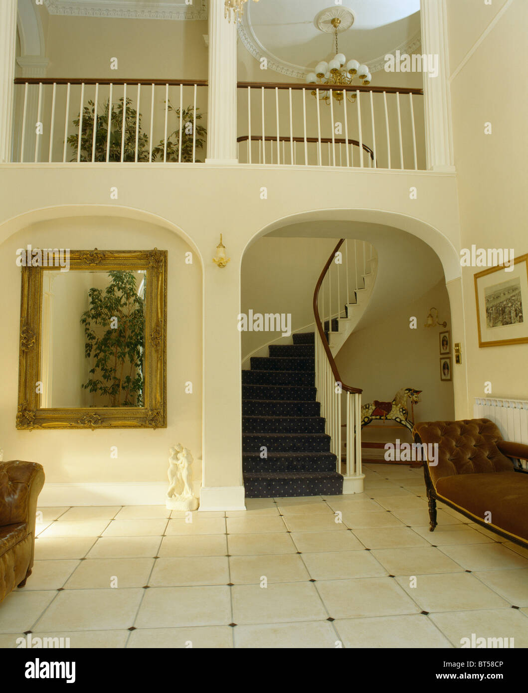 Mirror in alcove in large traditional hall with ceramic tiled floor and ...