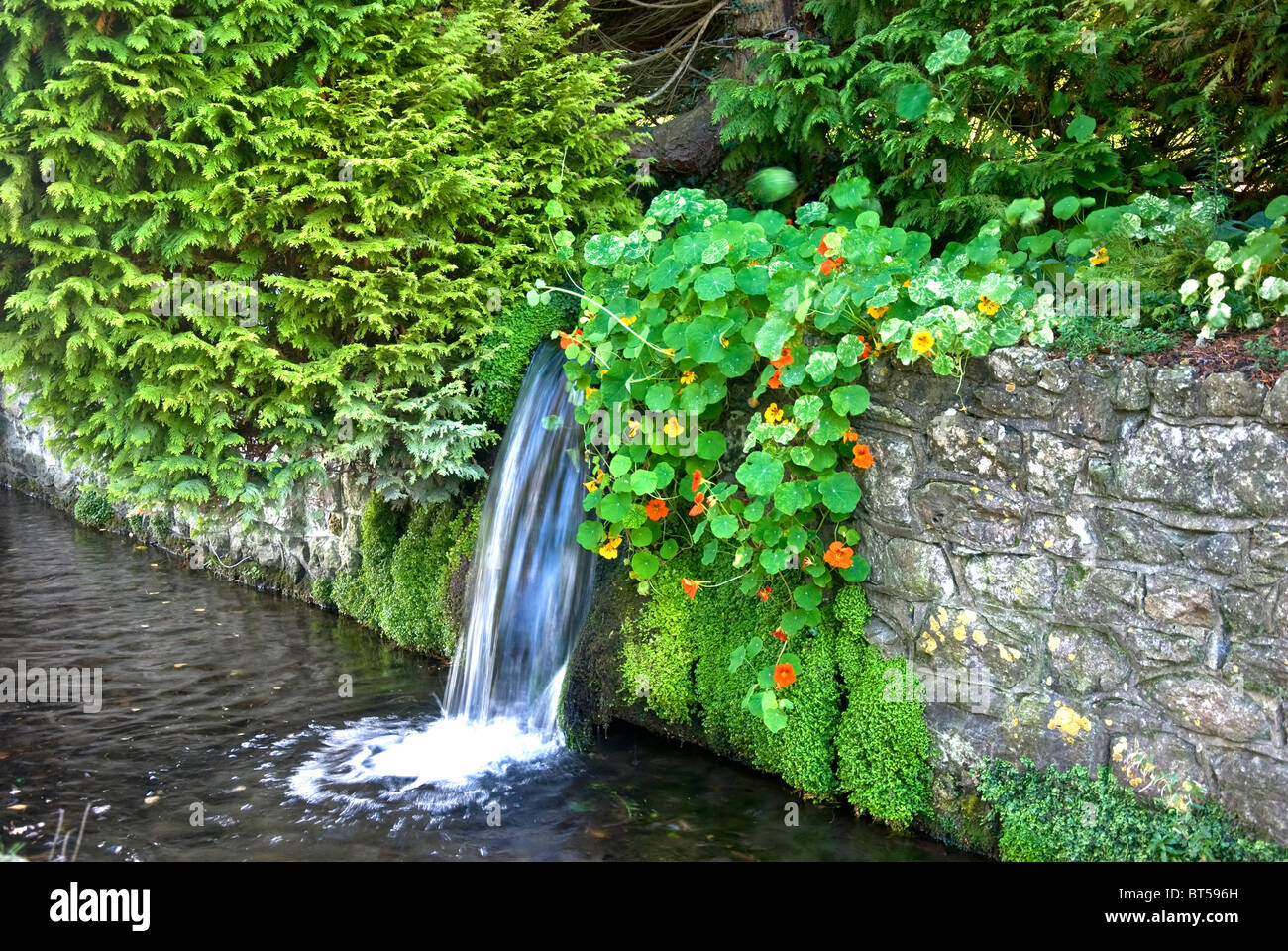 Small flow of water into a stream Stock Photo - Alamy