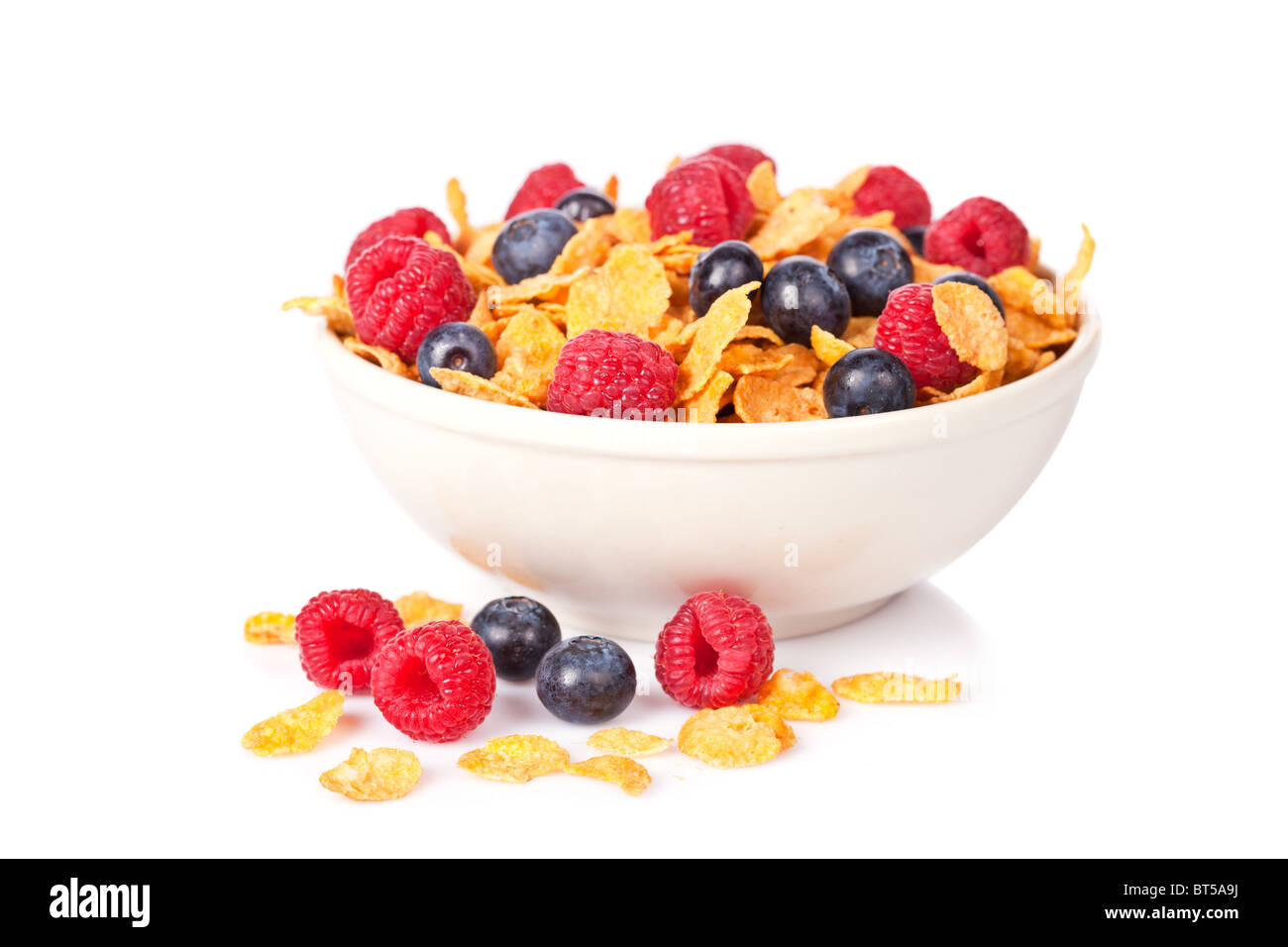 A bowl of cornflakes with fruits on white background. Shallow depth of ...