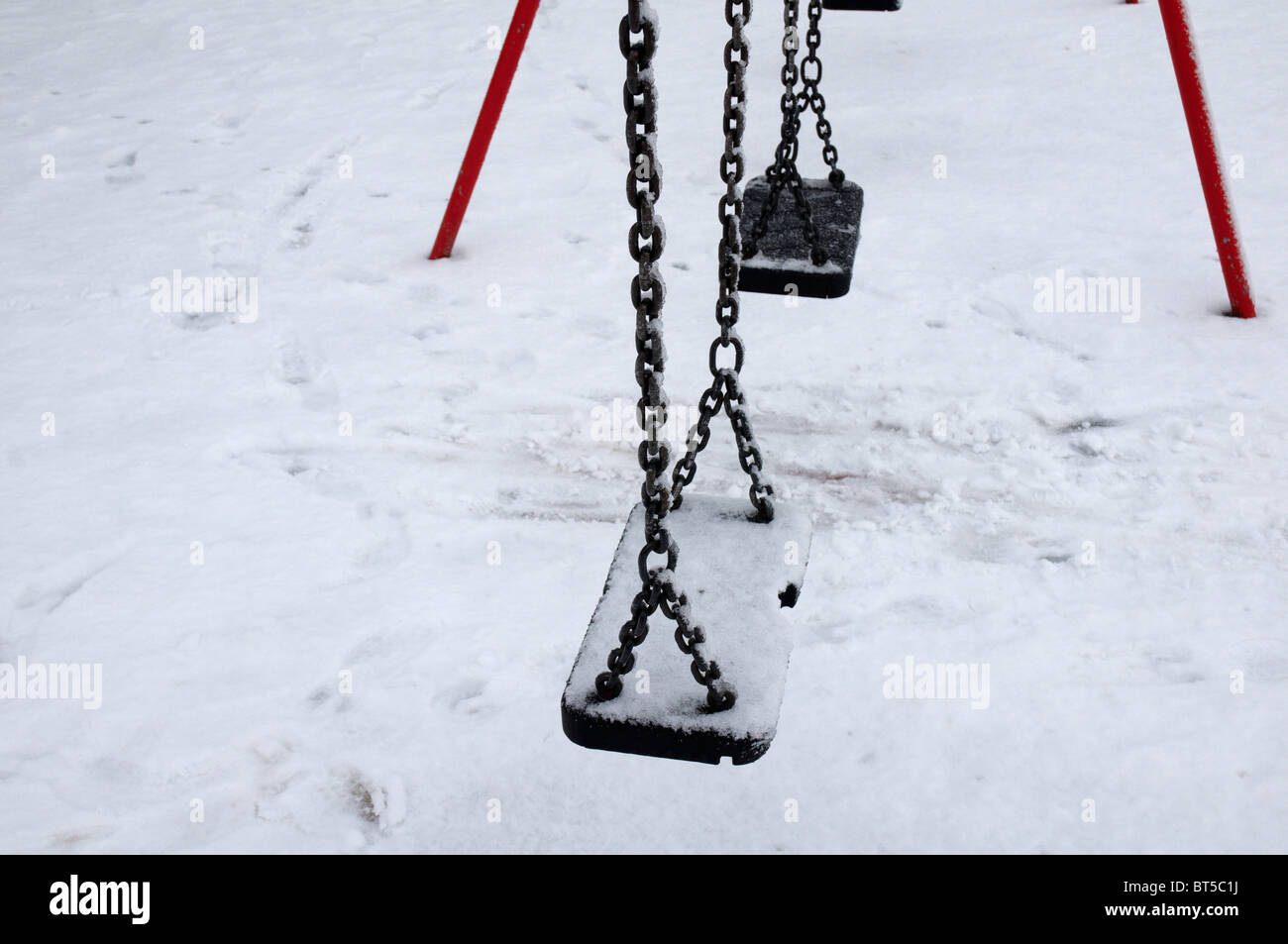 The seat of a swings covered in snow Stock Photo - Alamy