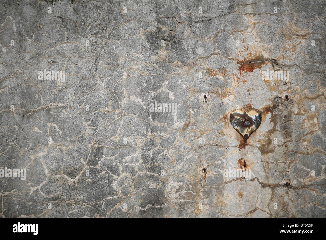An old heart ornament on a stone wall at a French gravesite Stock Photo ...