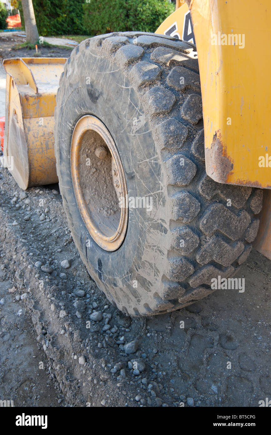 The side view of a yellow construction tractor, focus on the big front ...