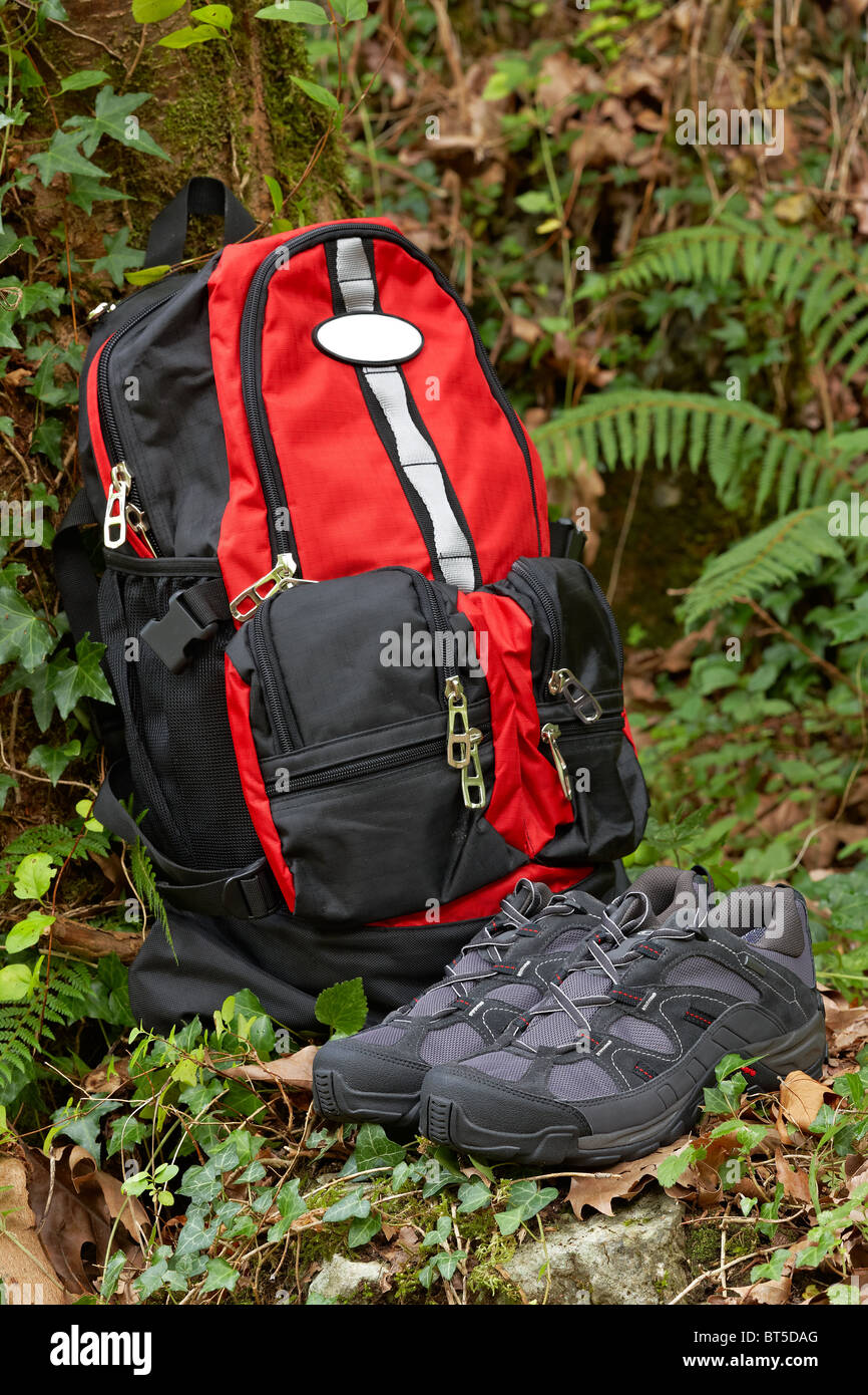 Hiking boots and backpack in the field. Shallow depth of field and ...