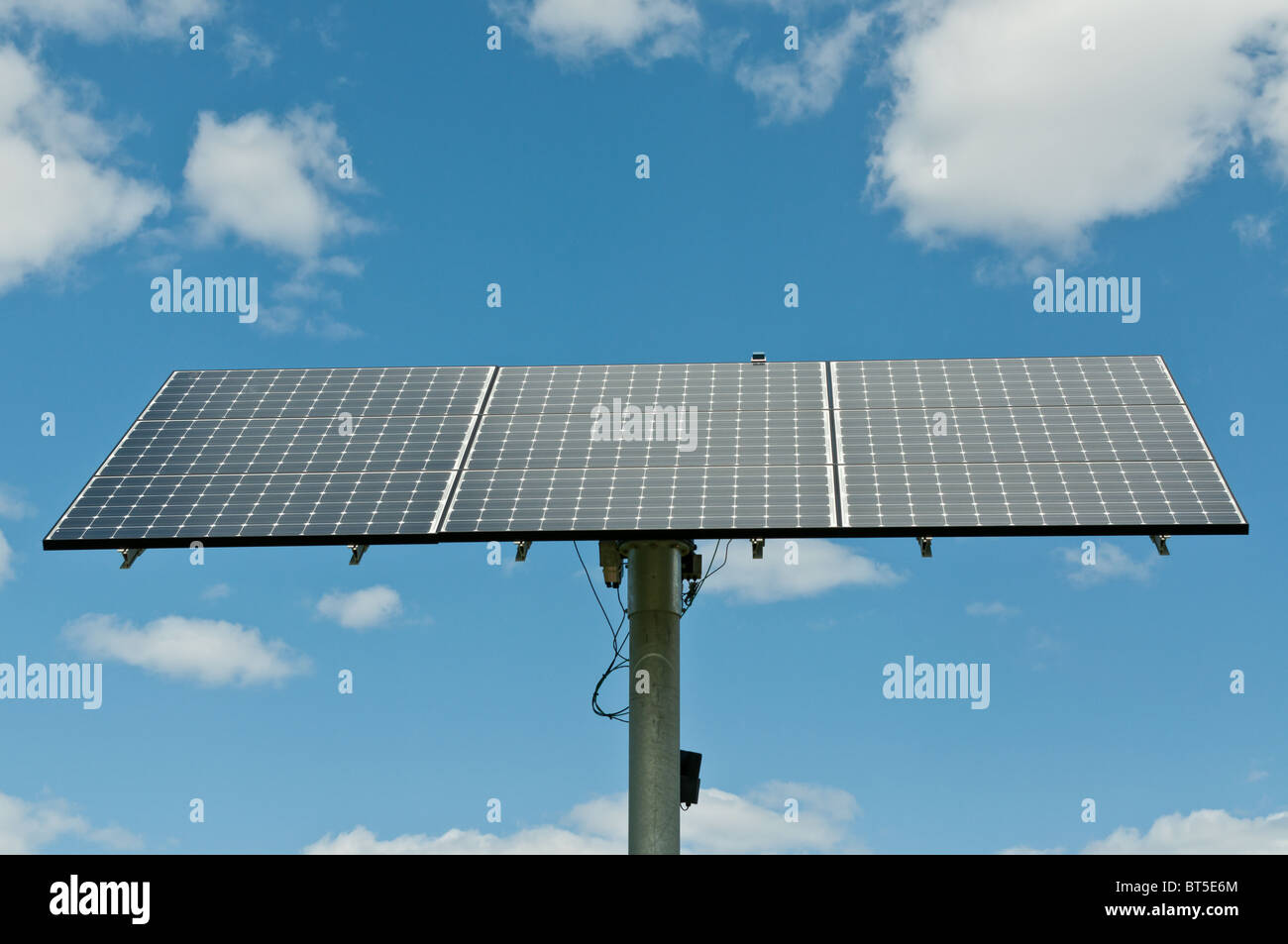 A modern photovoltaic solar panel array generates electricity with blue ...