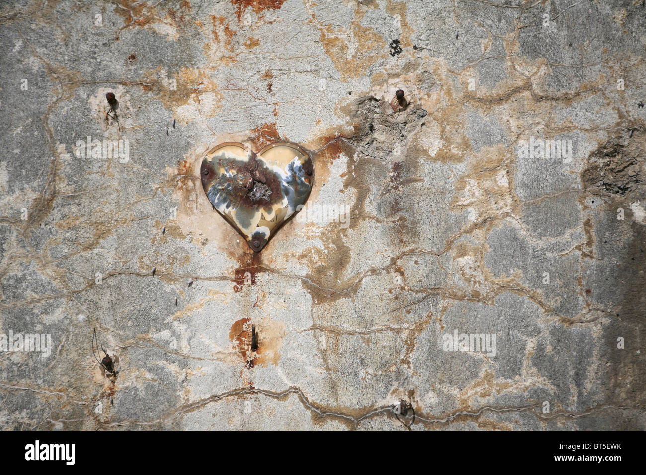 An old heart ornament on a stone wall at a French gravesite Stock Photo ...