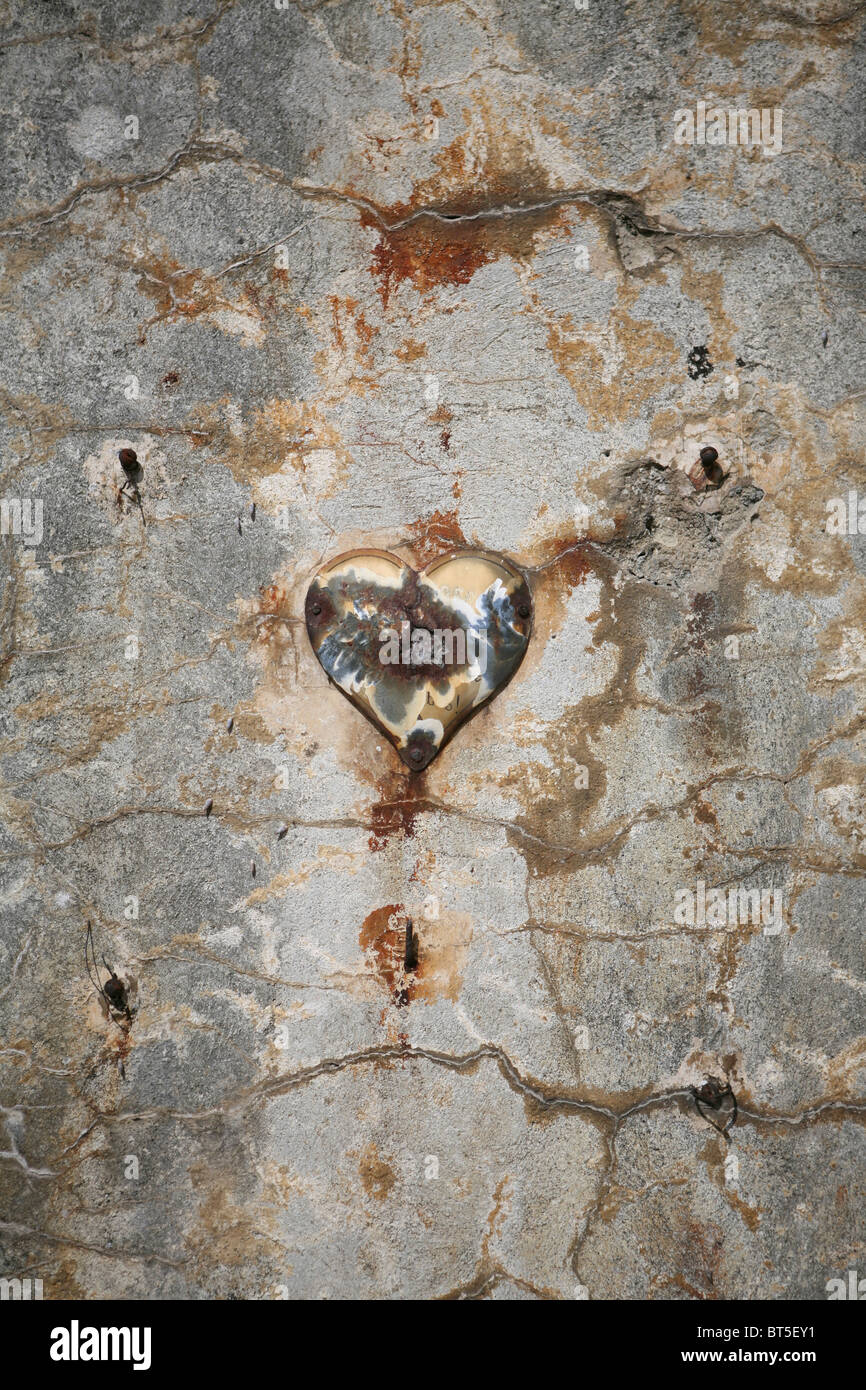 An old heart ornament on a stone wall at a French gravesite Stock Photo ...