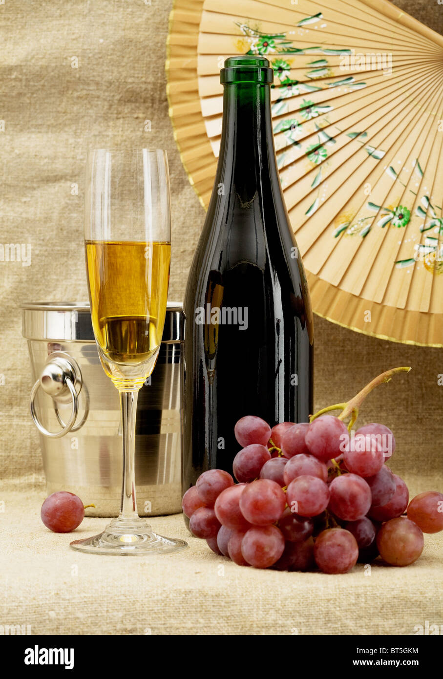Still life with champagne bottle, bucket, goblet and grapes Stock Photo ...