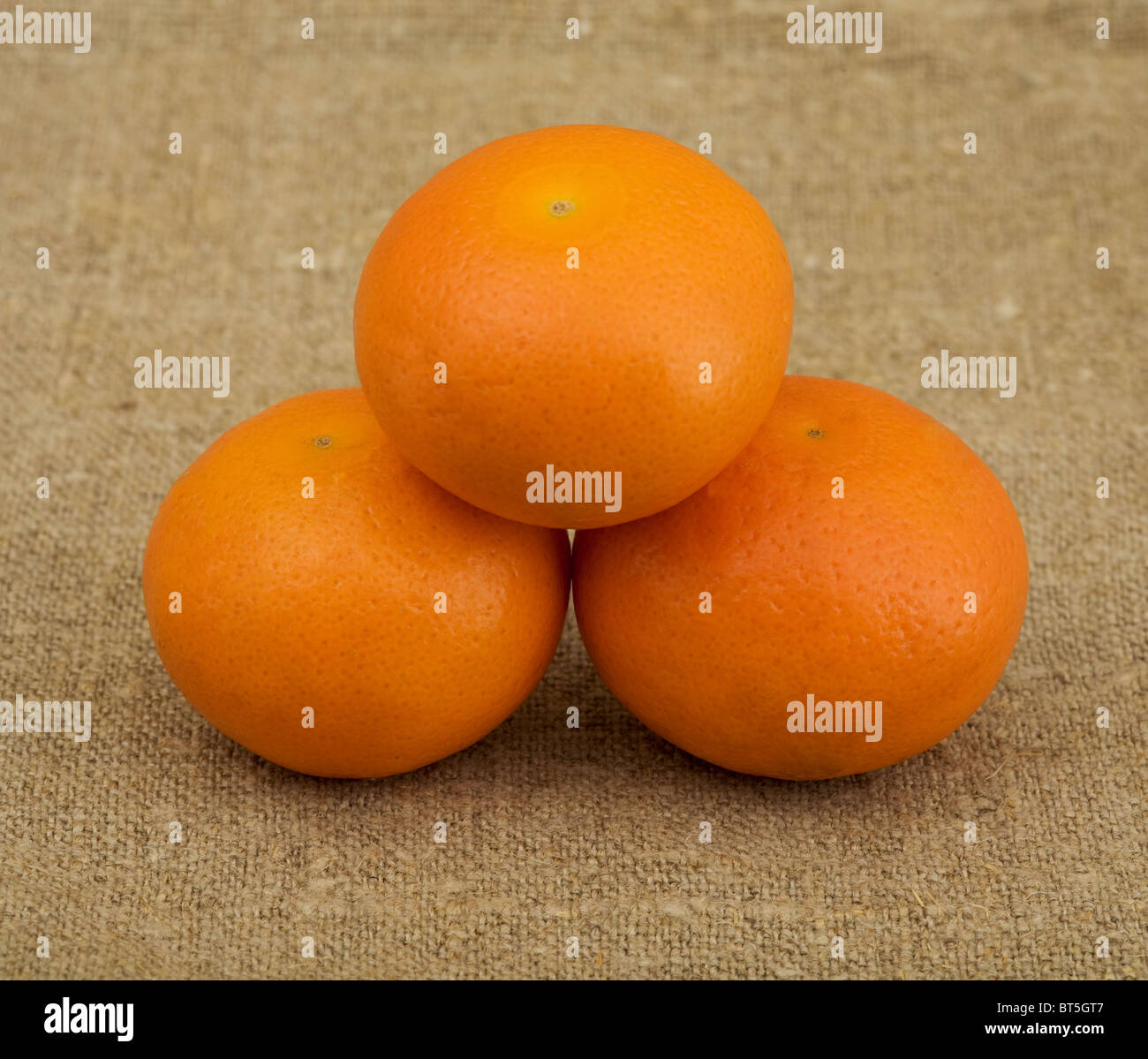 Three mandarin on the sacking background Stock Photo - Alamy