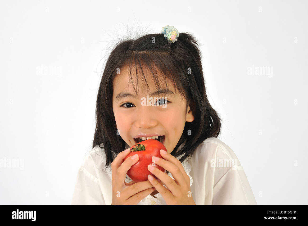 Girl eating tomato Stock Photo - Alamy