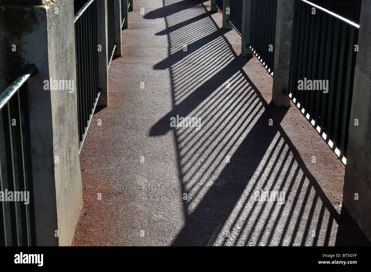 Shadows of railings on footbridge Stock Photo - Alamy