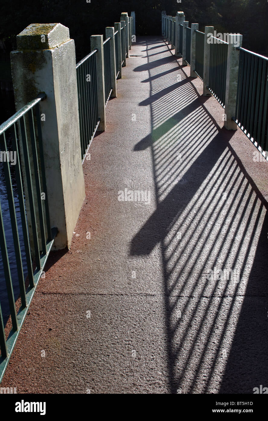 Shadows of railings on footbridge Stock Photo - Alamy