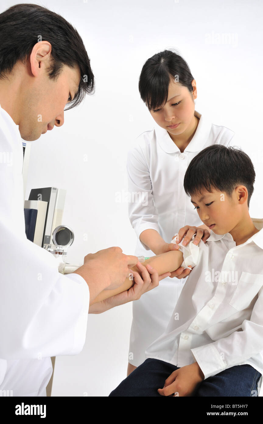 Male doctor and female nurse giving boy injection Stock Photo - Alamy