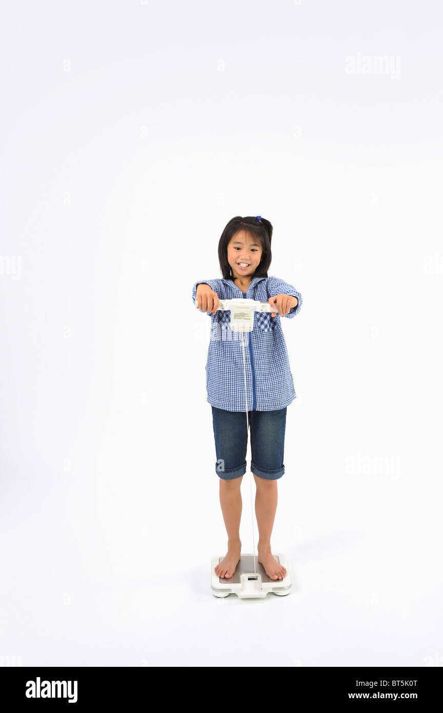 Girl standing on weight scale Stock Photo - Alamy