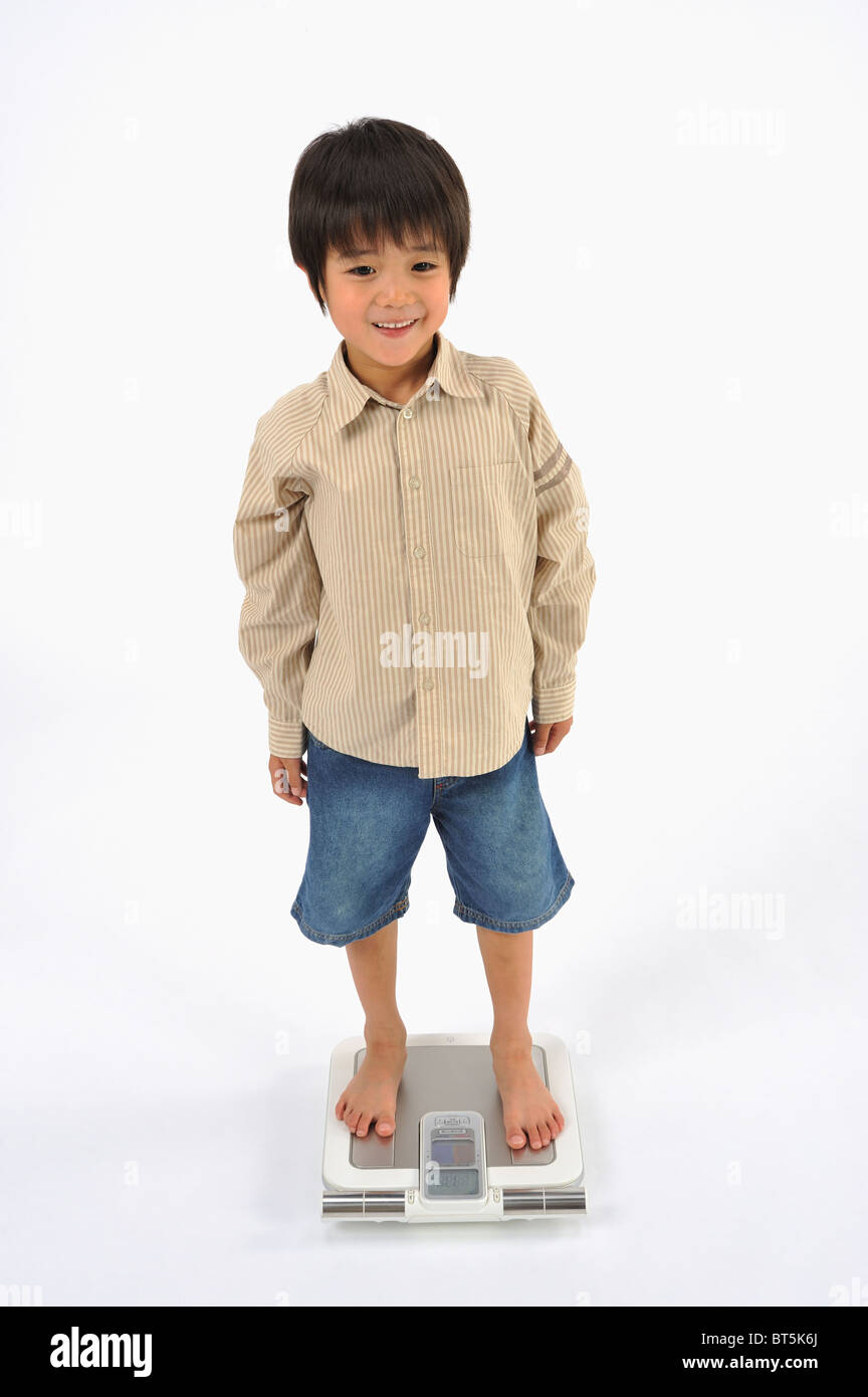 Boy standing on weight scale Stock Photo - Alamy