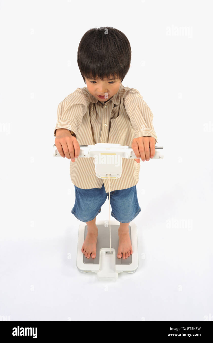 Boy standing on weight scale Stock Photo - Alamy