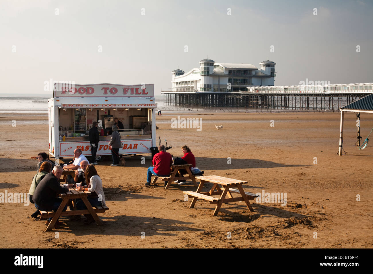 People eating and drinking at a fast food van on the beach along the ...