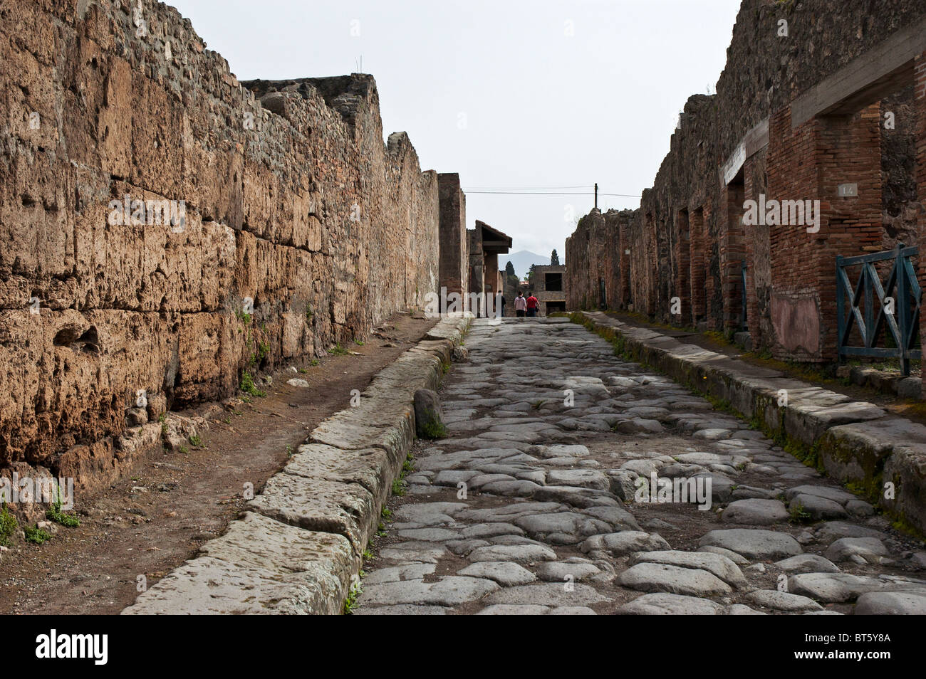 A straight Roman Street bordered on each side by ruins of houses and ...