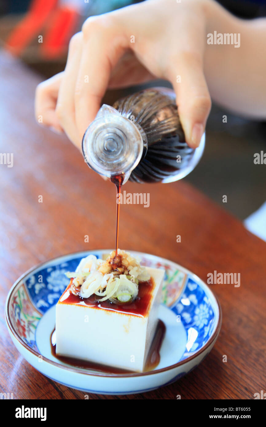 Human hand pouring soy sauce on tofu Stock Photo - Alamy
