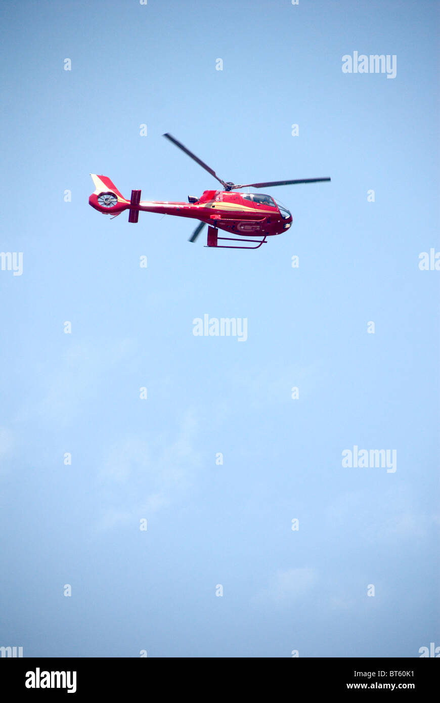 red flying helicoptor in sky above melbourne Stock Photo - Alamy