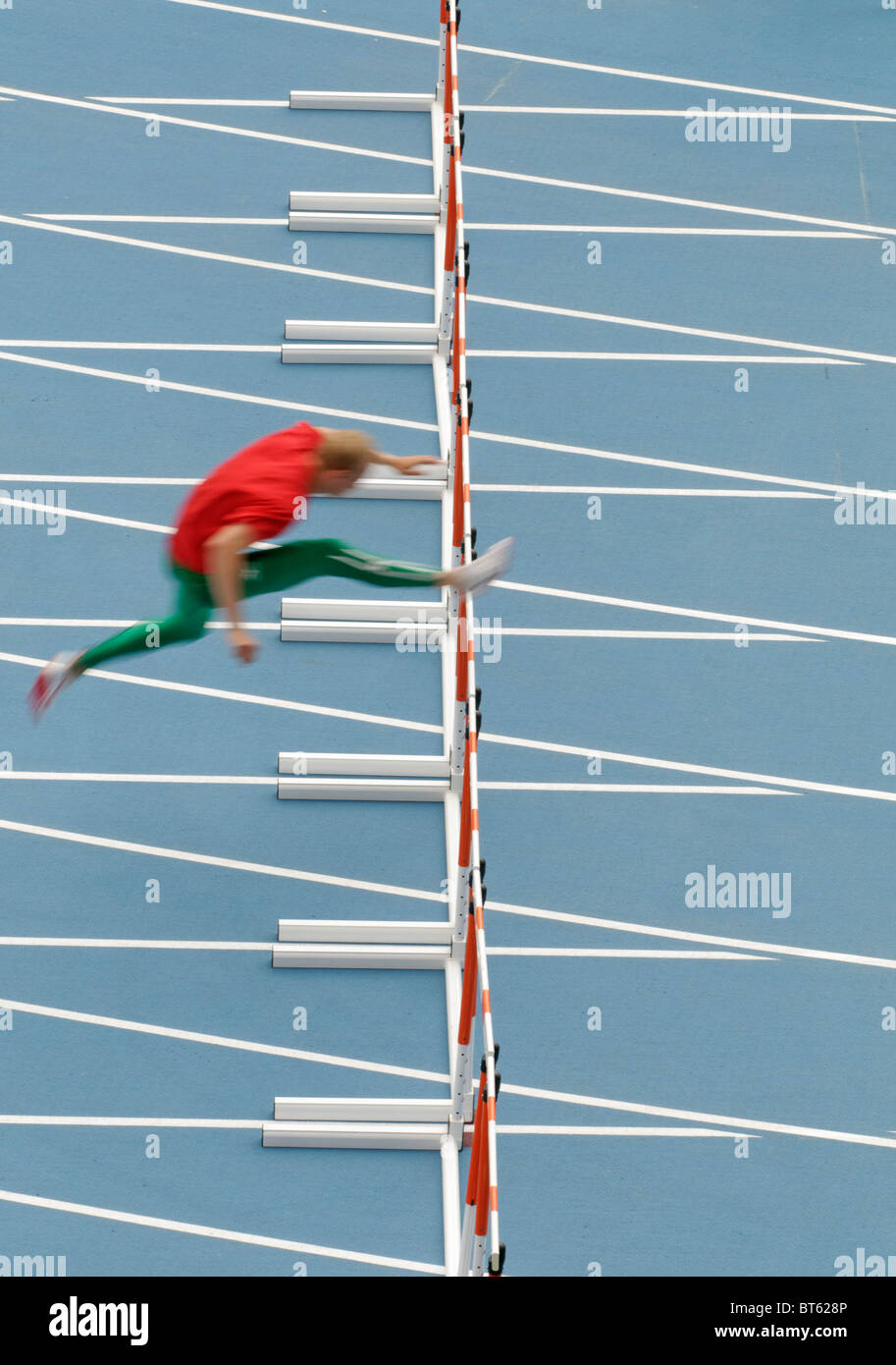 lone male sprinter jumps over hurdle during track and field event Stock ...