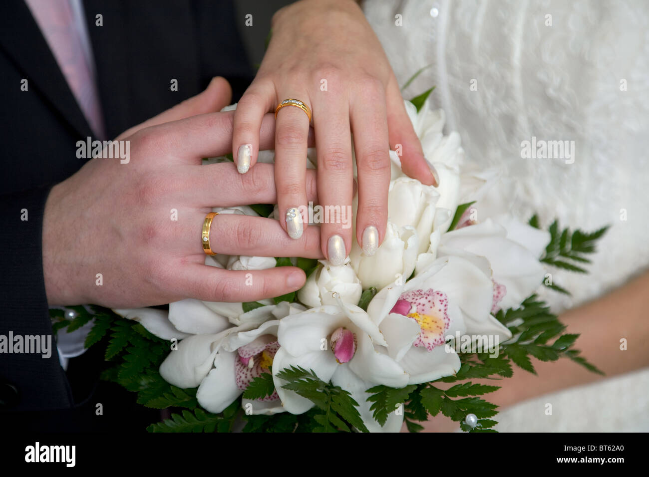 Hands with wedding rings and bunch of flower Stock Photo - Alamy