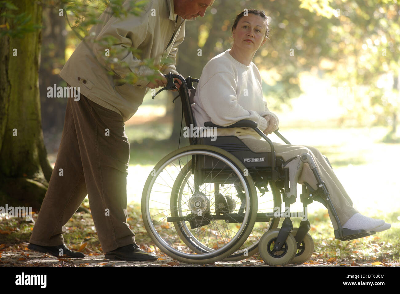 old man pushing woman on wheelchair Stock Photo - Alamy