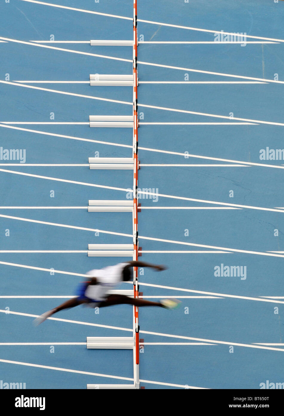 lone male sprinter jumps over hurdle during track and field event Stock ...