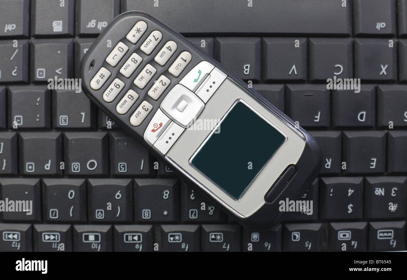 Mobile telephone lying on keyboard of the black colour Stock Photo - Alamy