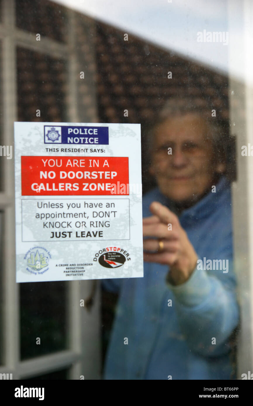vulnerable elderly woman pointing at a front door warning notice to ...