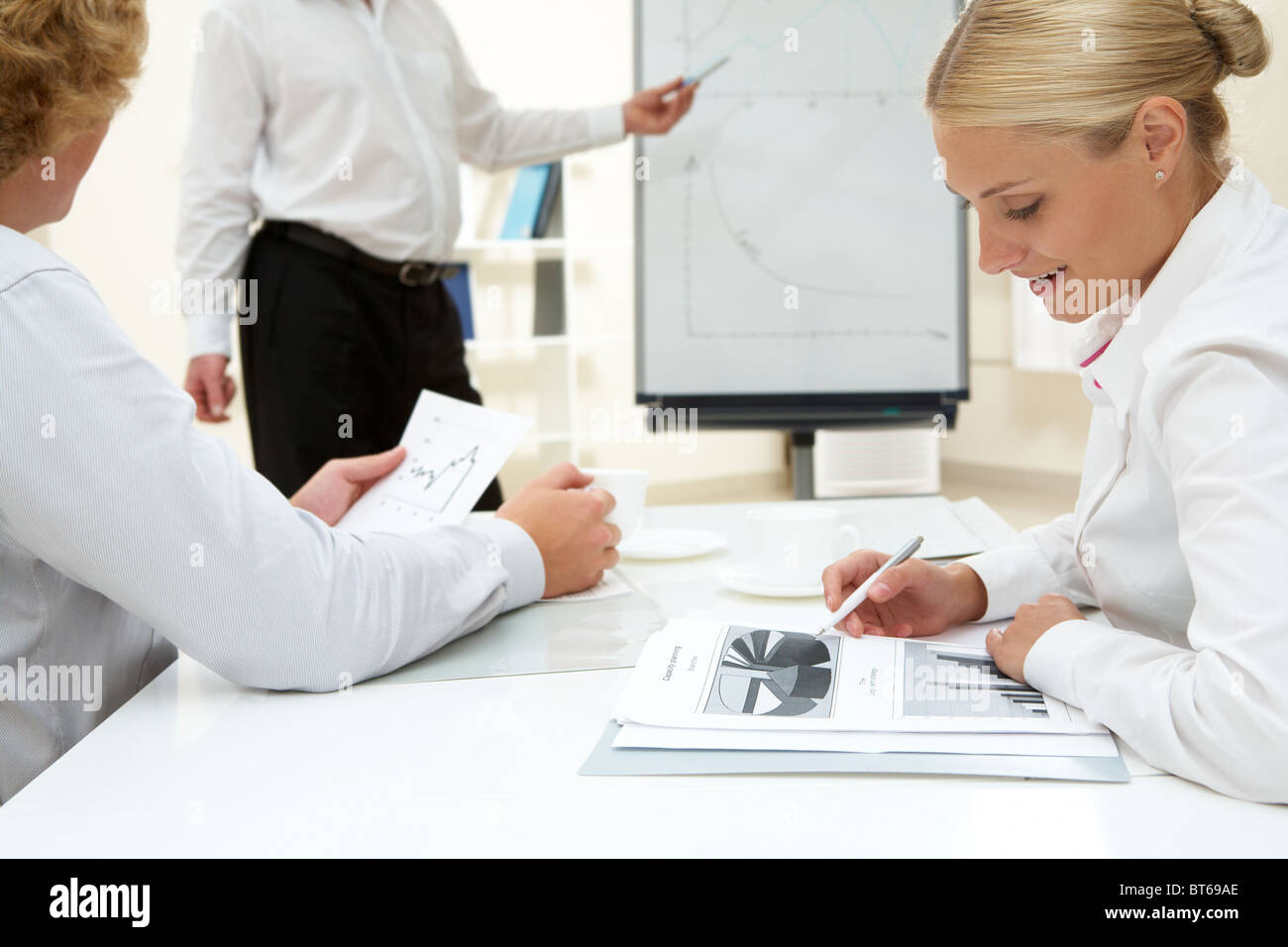 Photo of pretty student making notes at workplace on background of ...