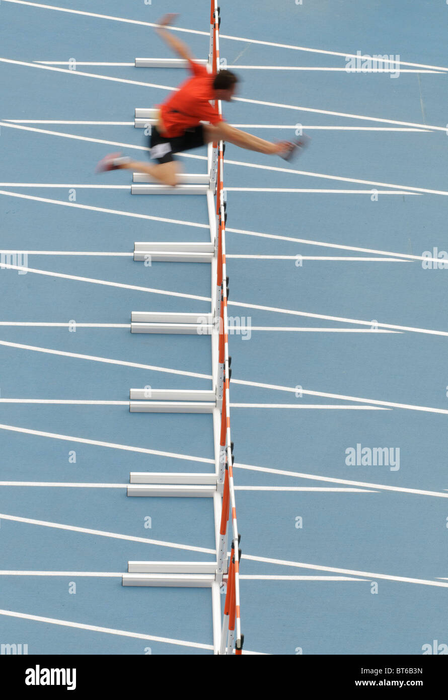 lone male sprinter jumps over hurdle during track and field event Stock ...